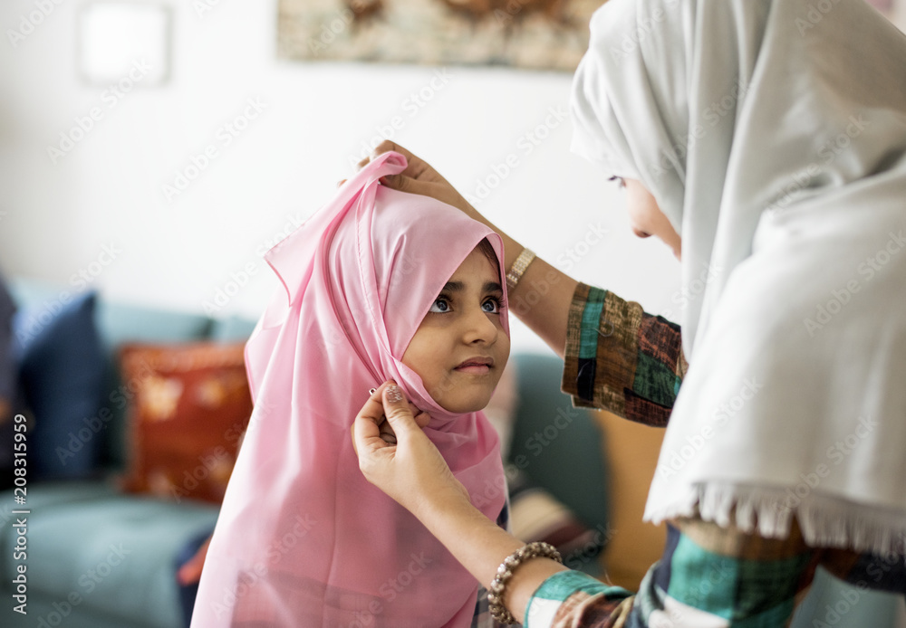 Muslim mom teaching daughter how to wear a Hijab Stock Photo | Adobe Stock