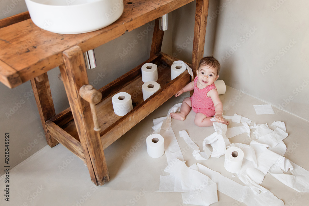Baby making mess in bathroom with toilet paper rolls Stock Photo ...