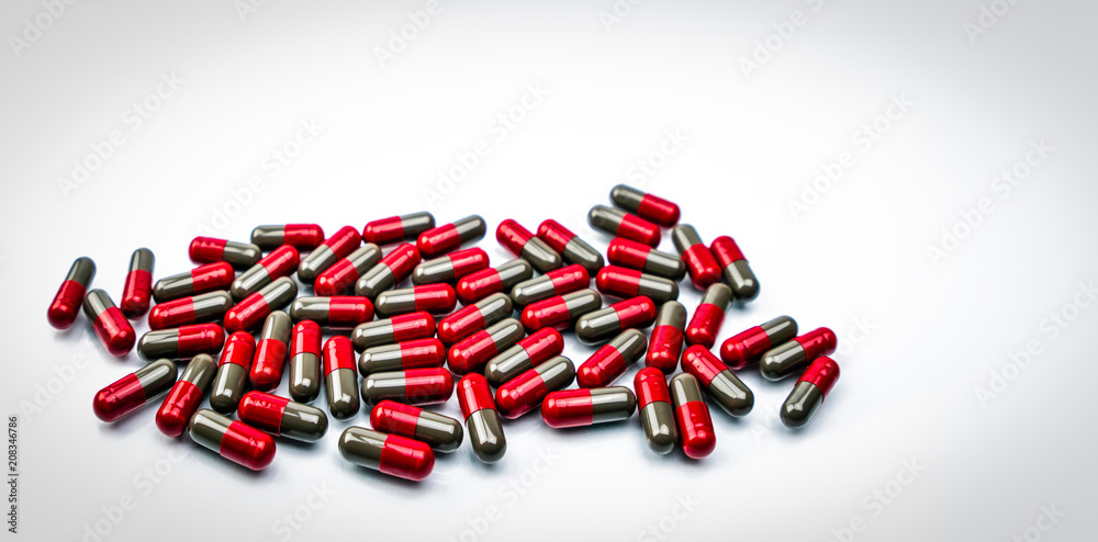 Pile of red and grey capsule pills isolated on white background with ...