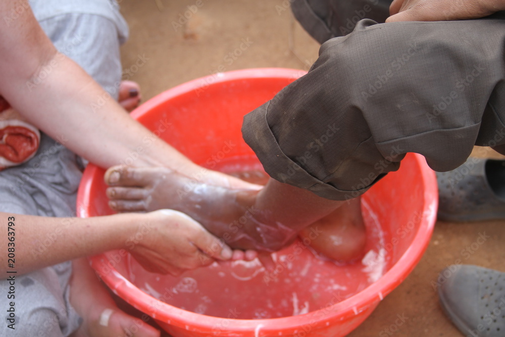 Volunteer washing a child's foot Stock Photo | Adobe Stock