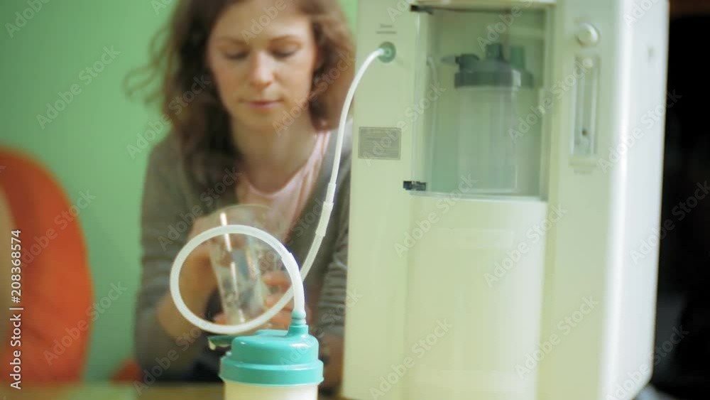 A woman drinks an oxygen cocktail with a device for oxygen scum. Oxygen ...