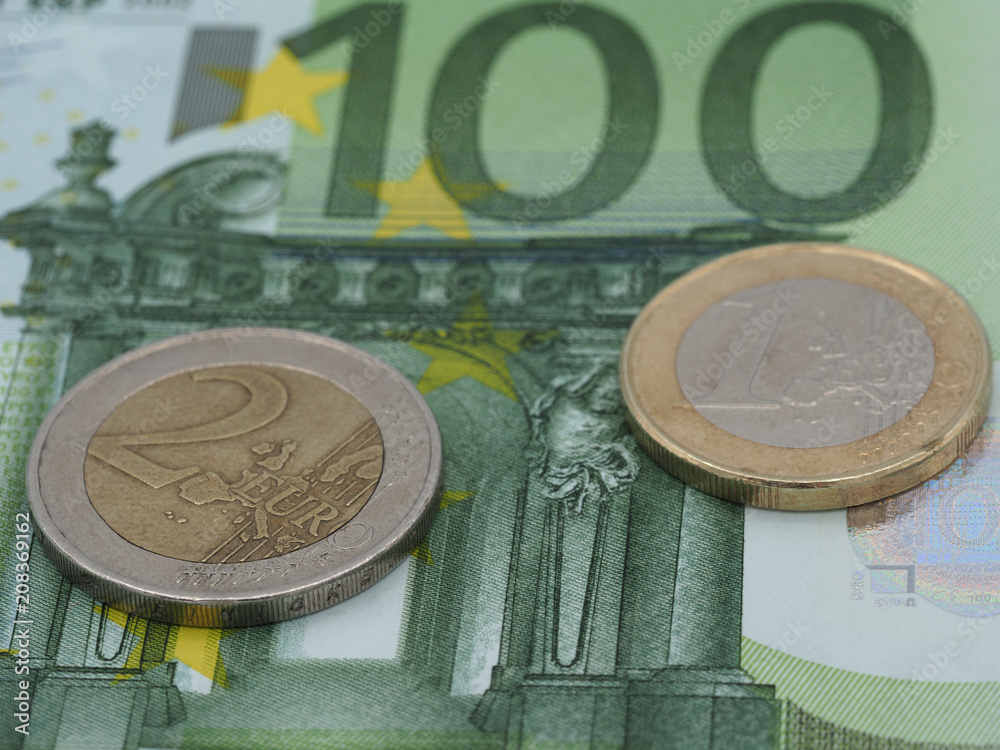 A high resolution image of a 1 and 2 euro coin on a 100 euro bill ...