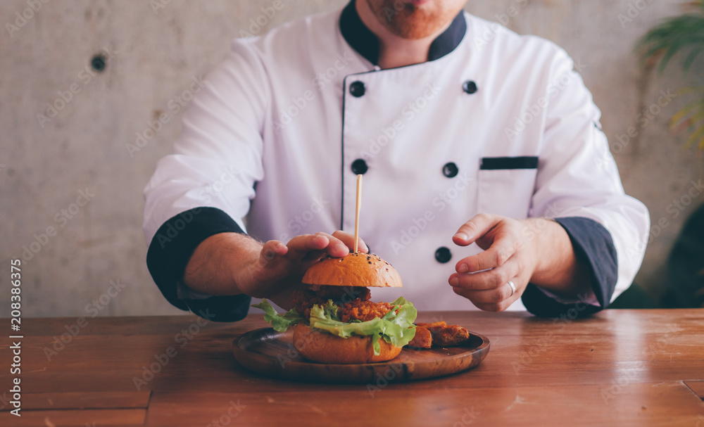 Chef making chicken burger in the kitchen. Stock Photo | Adobe Stock