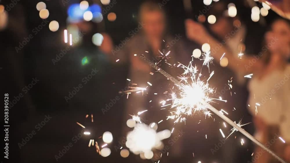 Firework sparkler burning at night with lights on background Stock ...