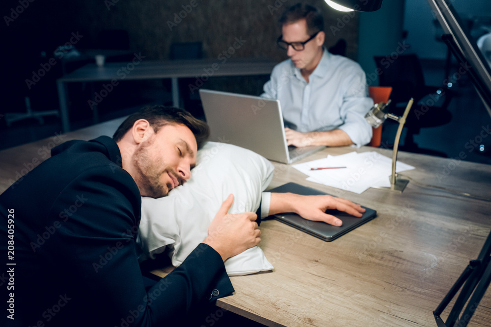 Young man fell asleep in office at night. Good looking businessman ...