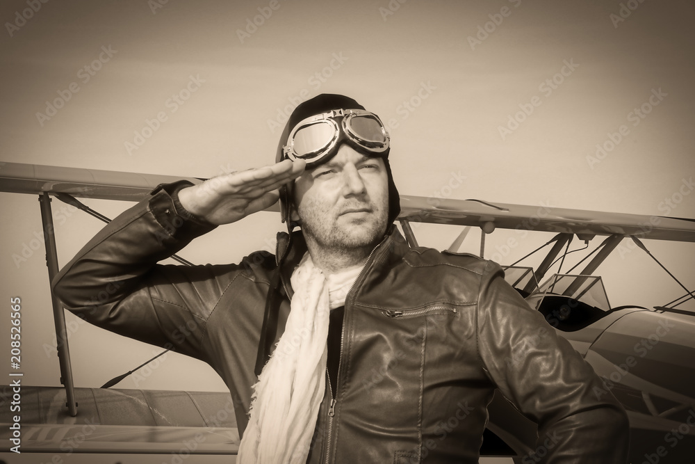 Portrait of a vintage pilot with leather cap, scarf and aviator glasses ...