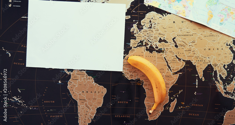 Banana on the black map of the world. The concept of tropical fruits ...