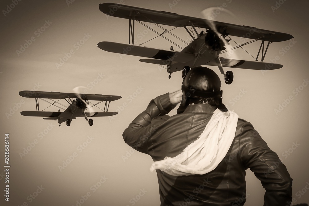Portrait of a vintage pilot with leather cap, scarf and aviator glasses ...