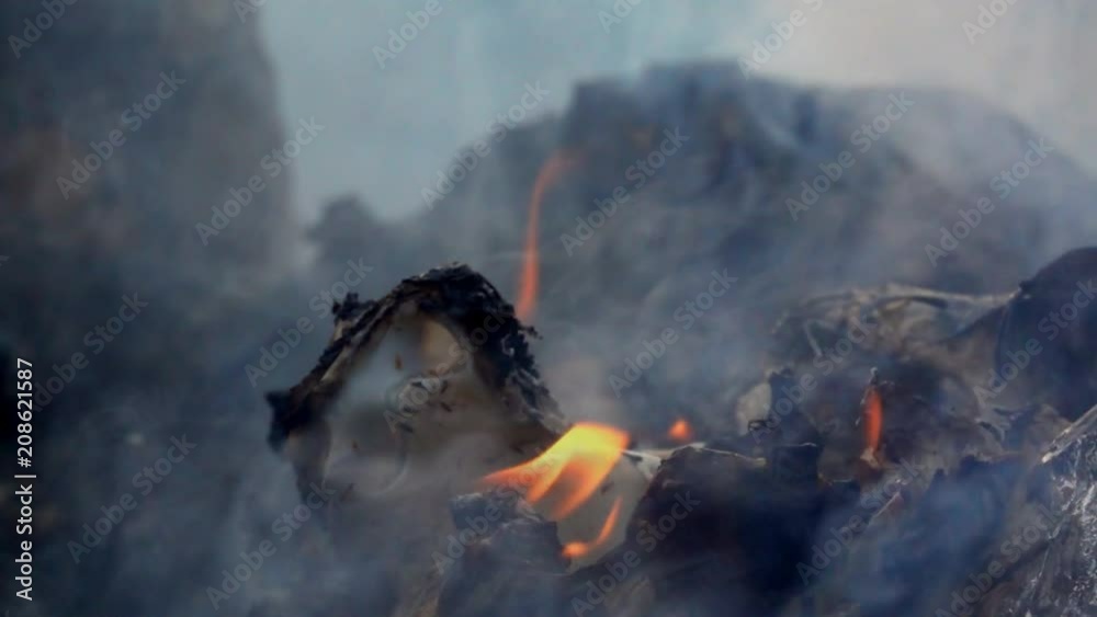 Slow motion fire burning garbage bag on sunrise dark backgorund. White ...