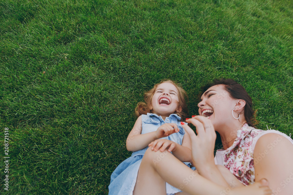 Overjoyed woman in light dress and little cute child baby girl lie on ...