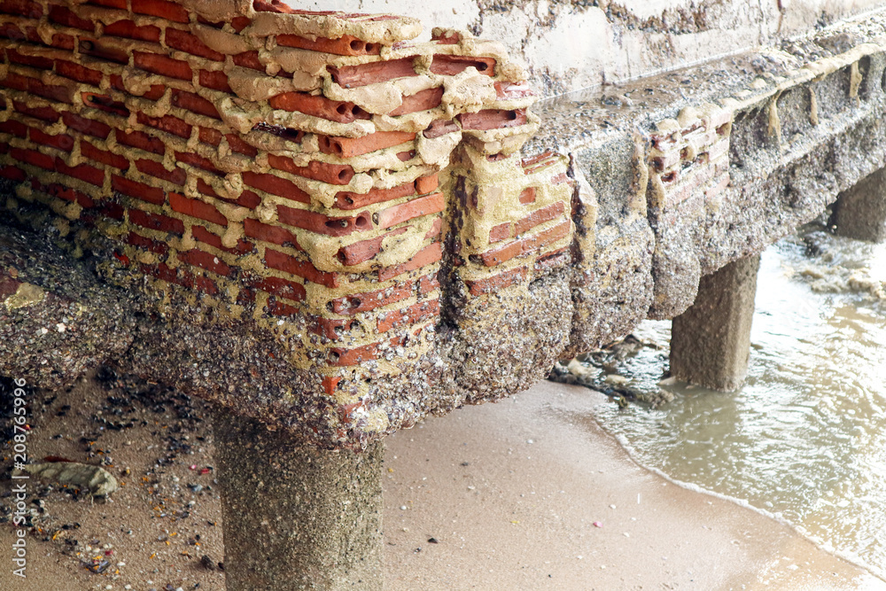 rust and erosion of brick wall building on beach was damage by storm ...