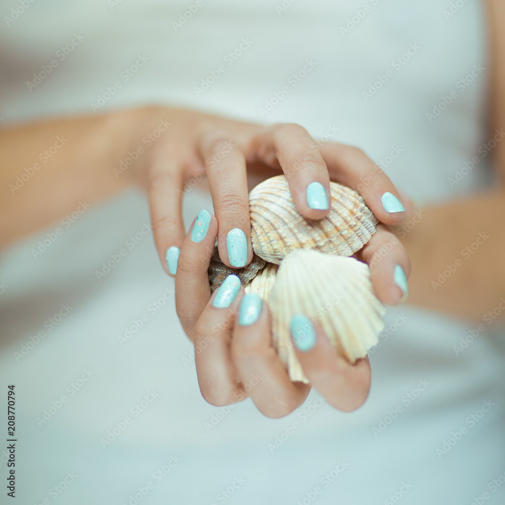 Beautiful woman hands with perfect nail polish holding little sea shell ...