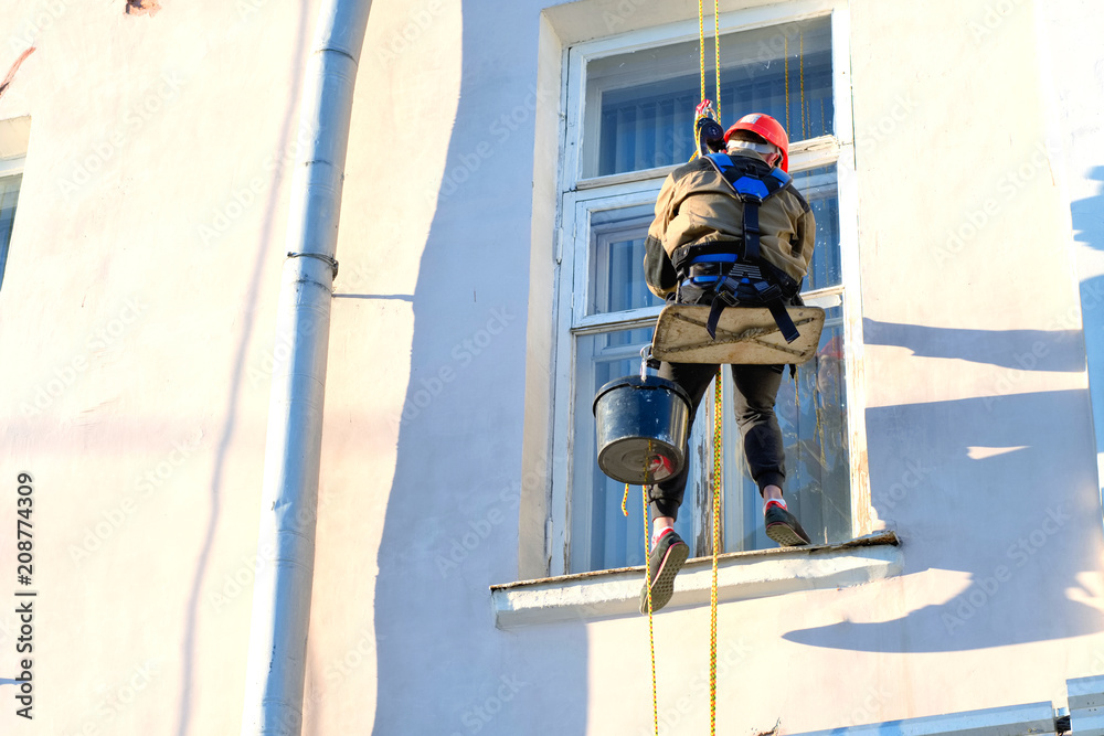 The man worker climbing at construction site with helmet and uniform ...