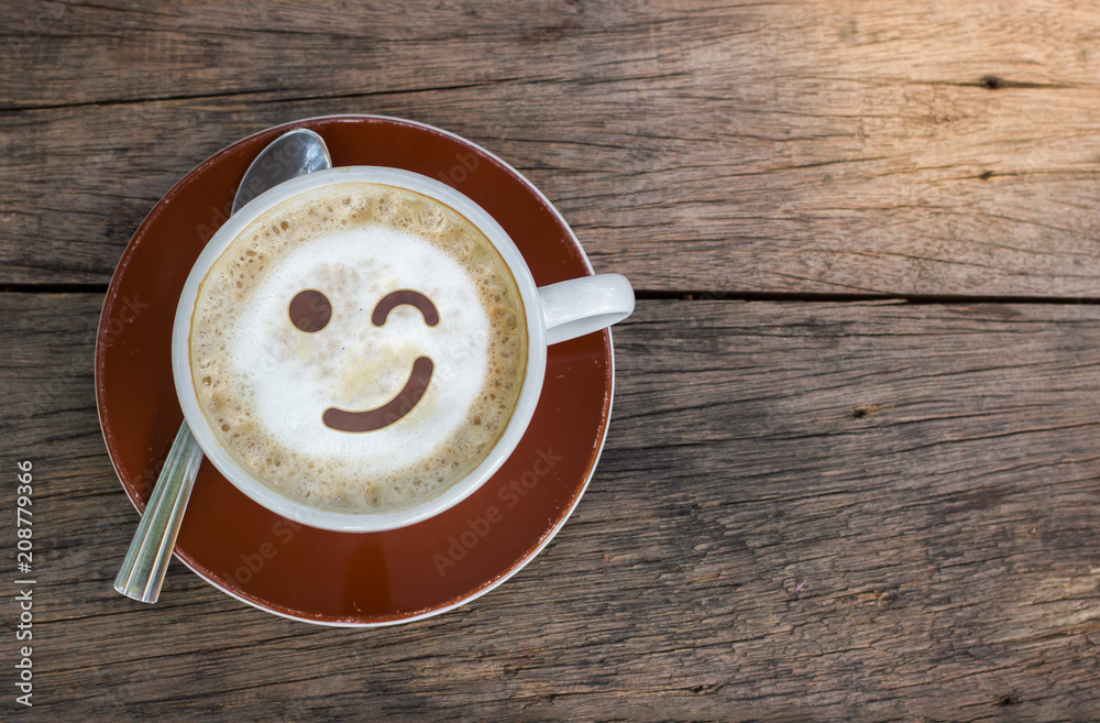 Top view of coffee cup with white foam and smile emotion face on wood ...