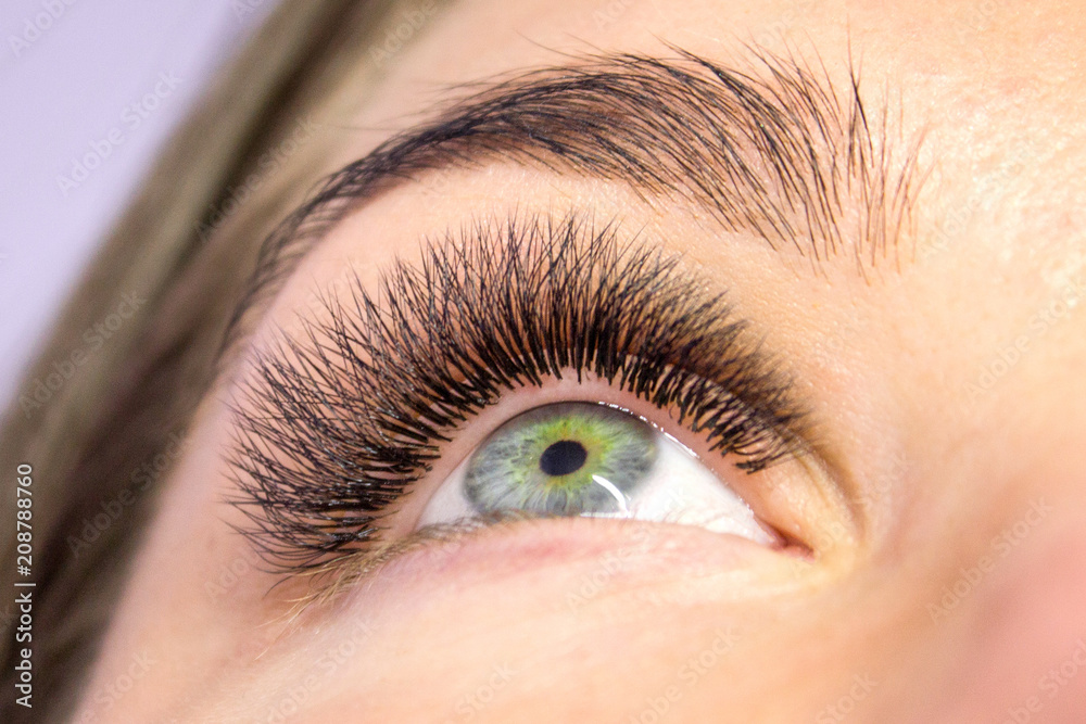 Beautiful Woman with long lashes in a beauty salon. Eyelash extension ...