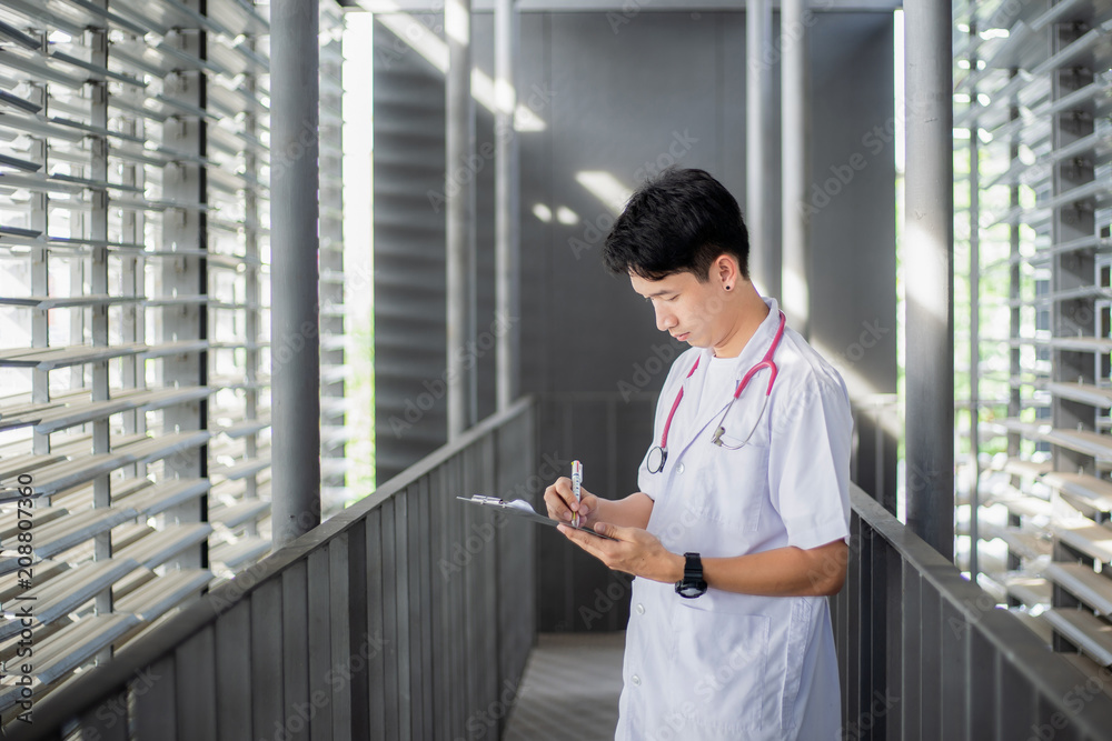 Young doctor writing notes on clipboard paper as copy space for patient ...