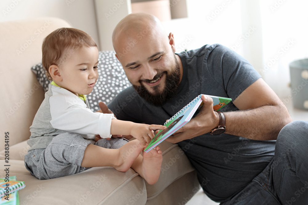 Dad reading book with his little son in living room Stock Photo | Adobe ...