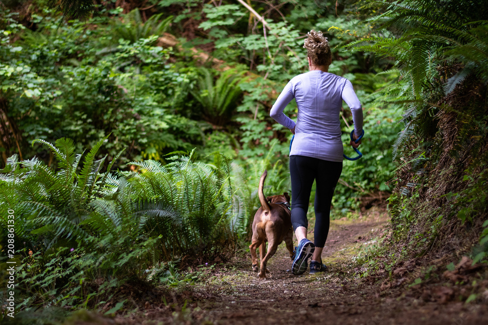 Female baby boomer in a purple top and black running pants on an ...