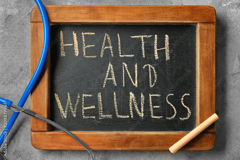 Blackboard with phrase "Health and wellness" and stethoscope on grey ...
