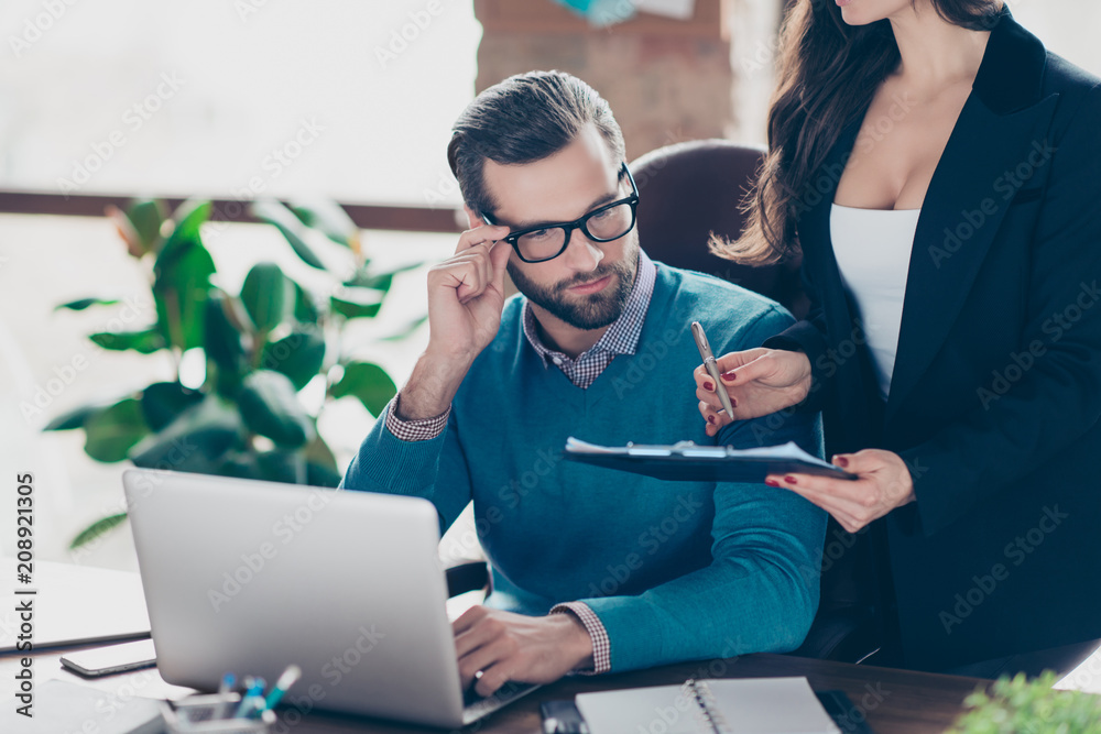 Concentrated, busy director using laptop holding eyelet of glasses on ...