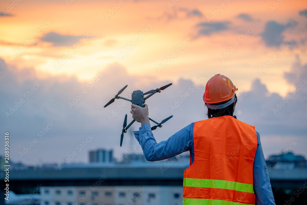 Fotografia do Stock: Young Asian engineer holding drone at construction ...