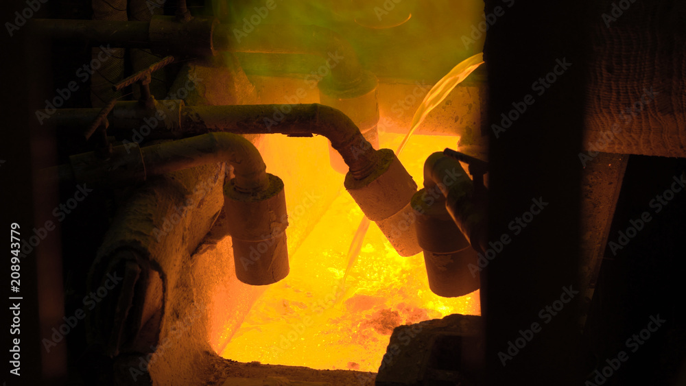 Hot steel pouring at steel plant. In the frame, molten metal is poured ...