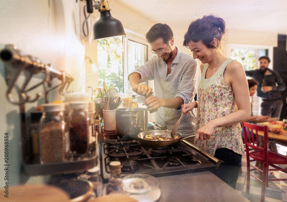 Mixed group of friends have fun while cooking a meal in kitchen Stock ...