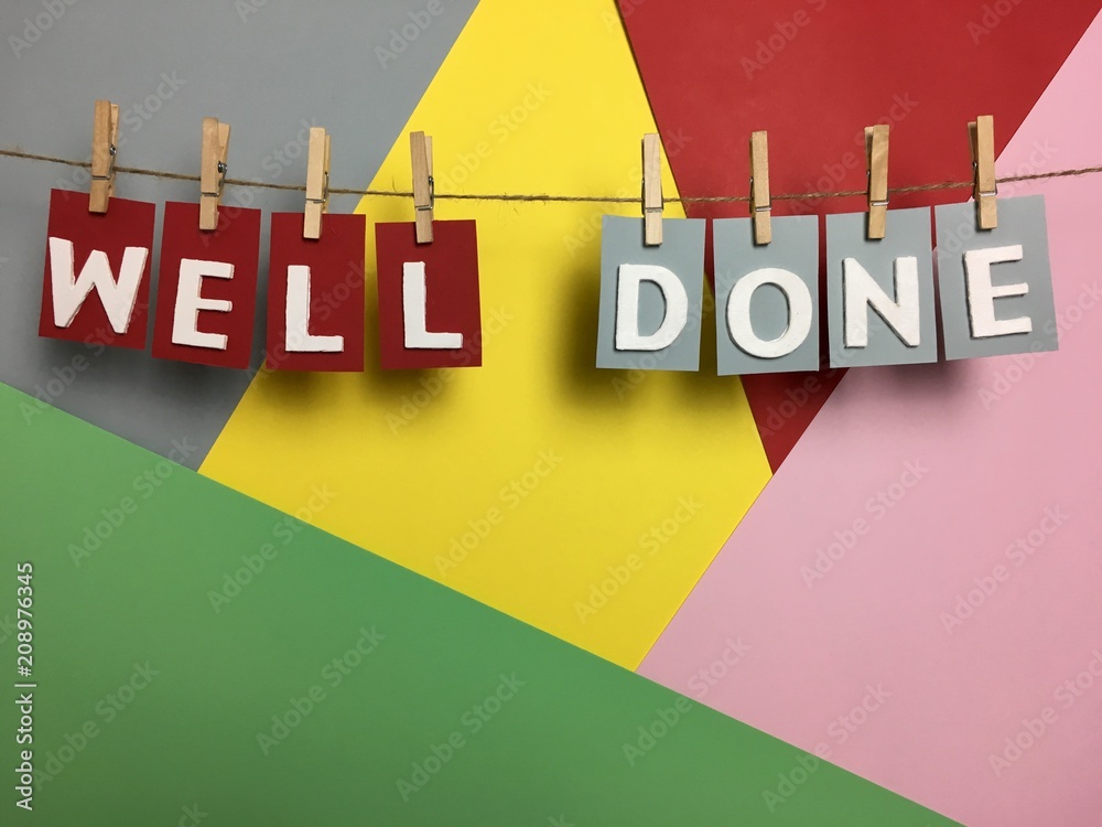 Frase “well done” colgada de una cuerda sobre fondo de colores. Stock ...