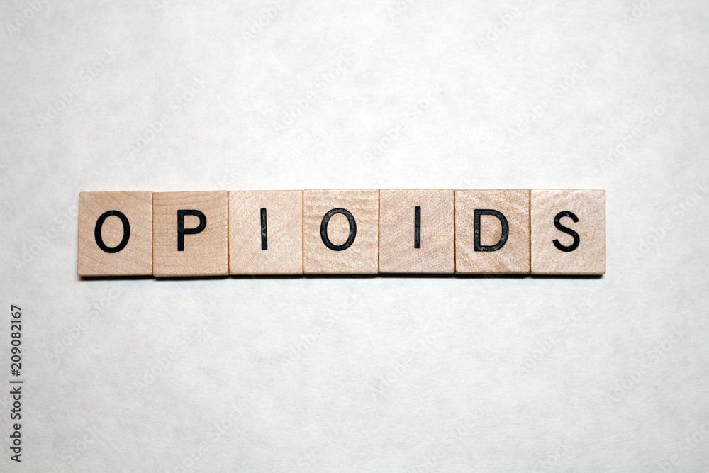 Opioids written on wooden blocks with black letters on a white ...