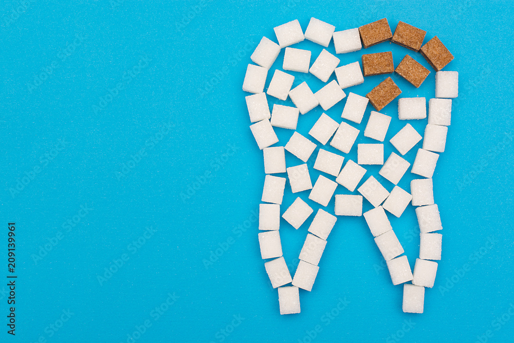 Sugar cubes are laid out in the form of a tooth, and brown sugar ...