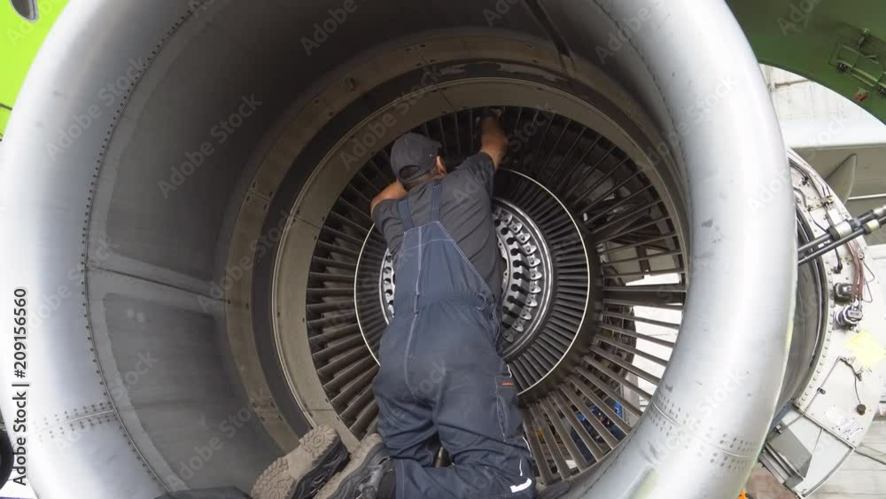 Maintenance of passenger aircraft. Engineer checks the aircraft engine ...