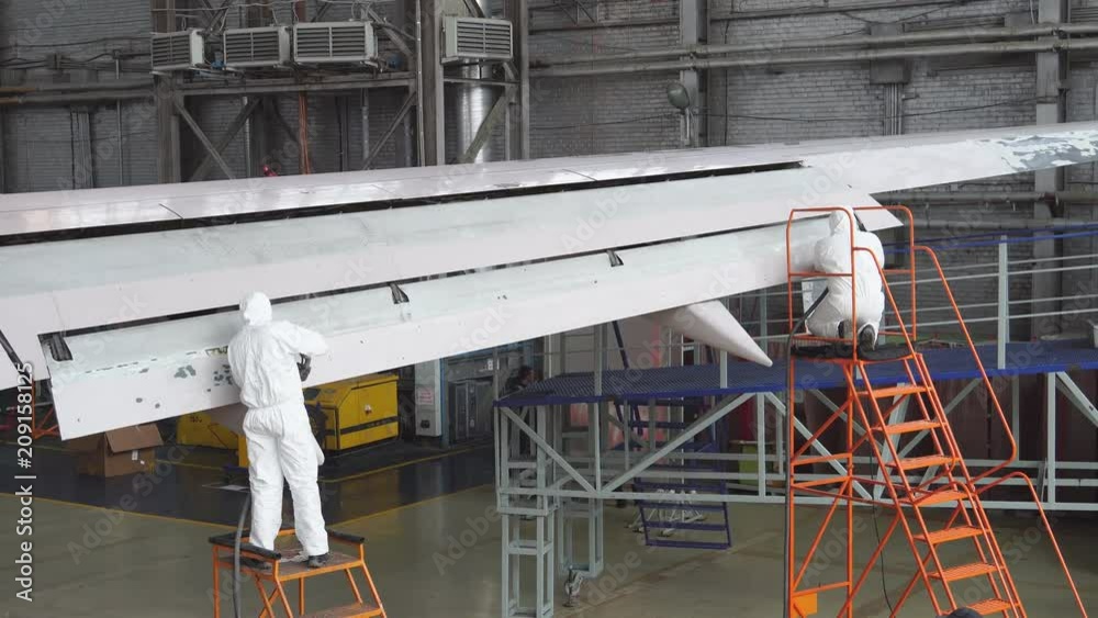 Repair of an aircraft wing. Painting the wing of the aircraft in white ...