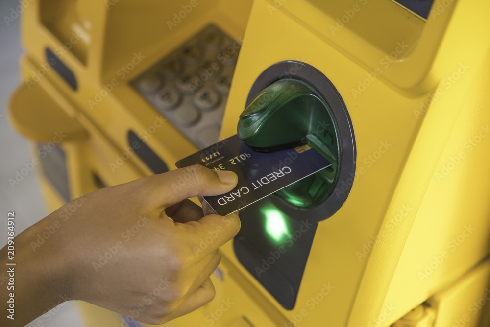 Hand inserting with a credit card into bank machine . Man using an atm ...