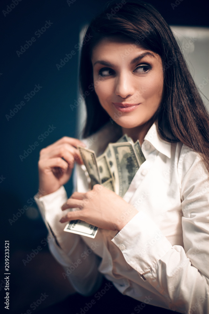Suspicious business woman hiding cash inside of her bra. Close portrait ...