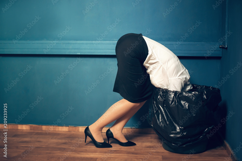 Girl getting stuck in garbage can. Lady wearing blouse skirt and black ...