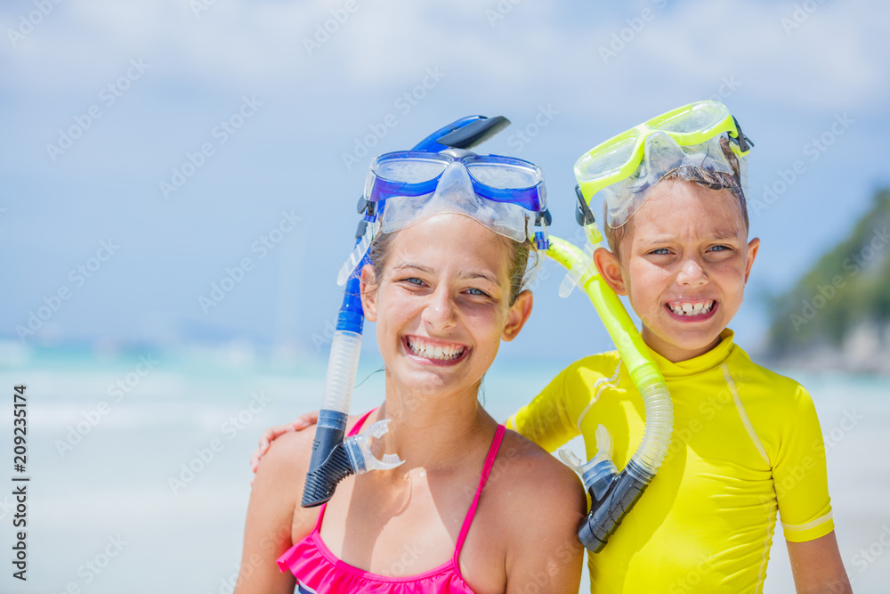 Portrait Of Brother And Sister In Scuba Masks Playing On The Beach During The Hot Summer