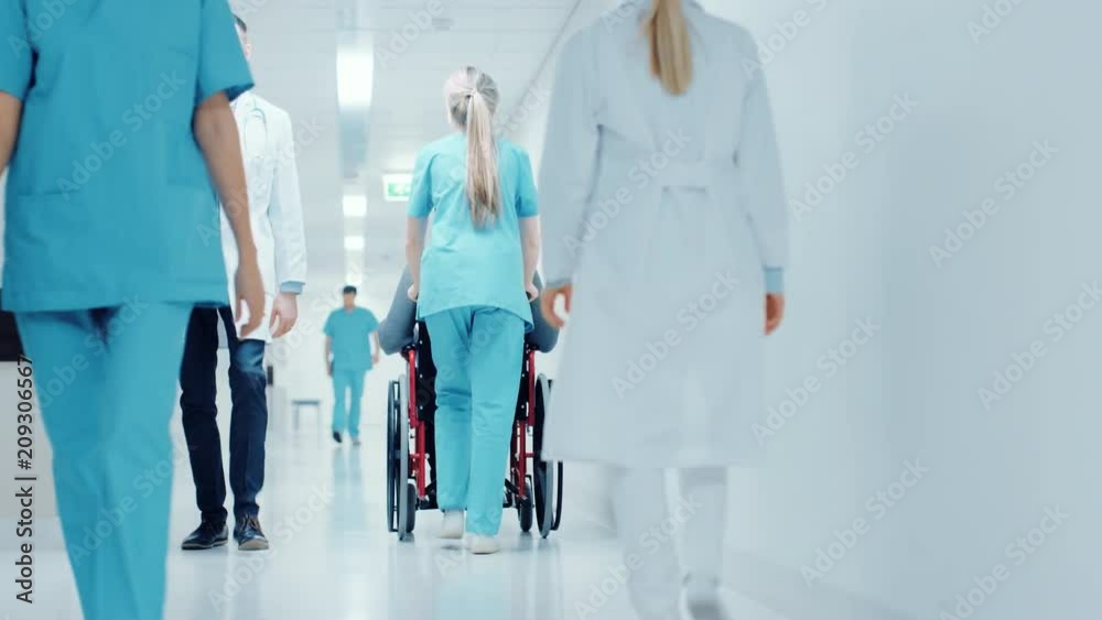 Following Shot of the Female Nurse Moving Patient in the Wheelchair ...