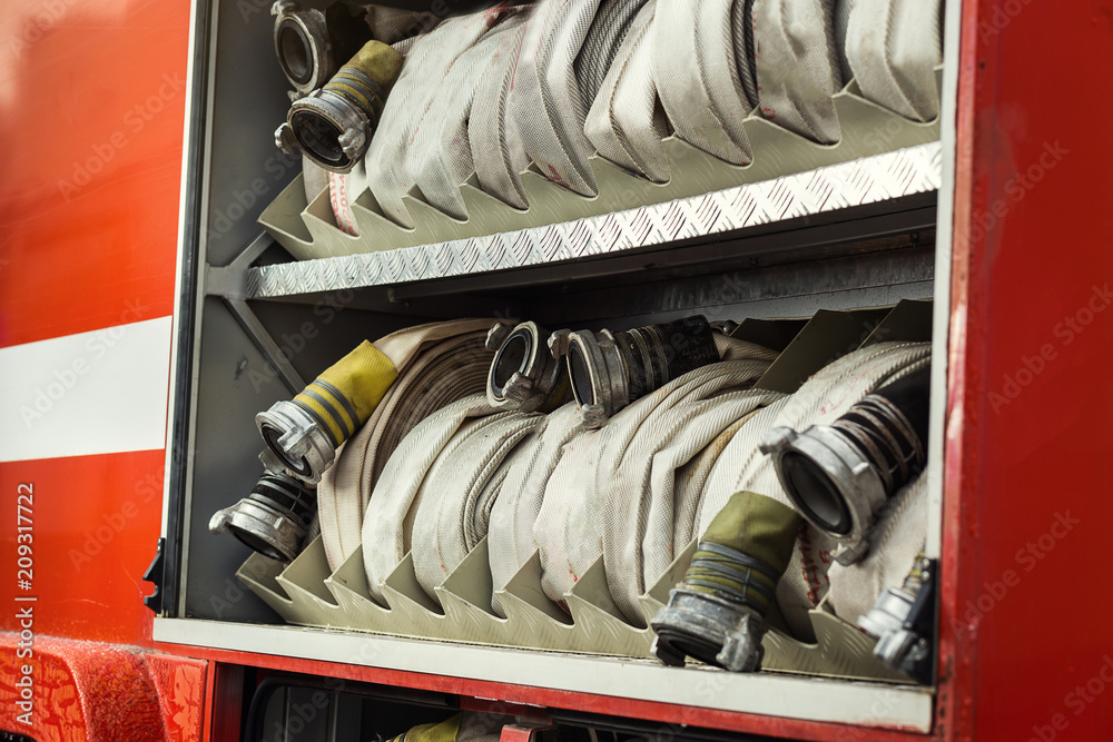 Compartment of rolled up fire hoses on a fireengine. Emergency safety ...