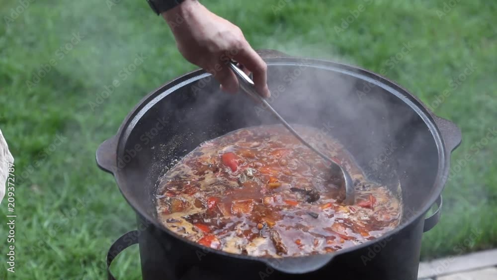 Soup in a cauldron made from vegetables and meat, in a cauldron on the ...