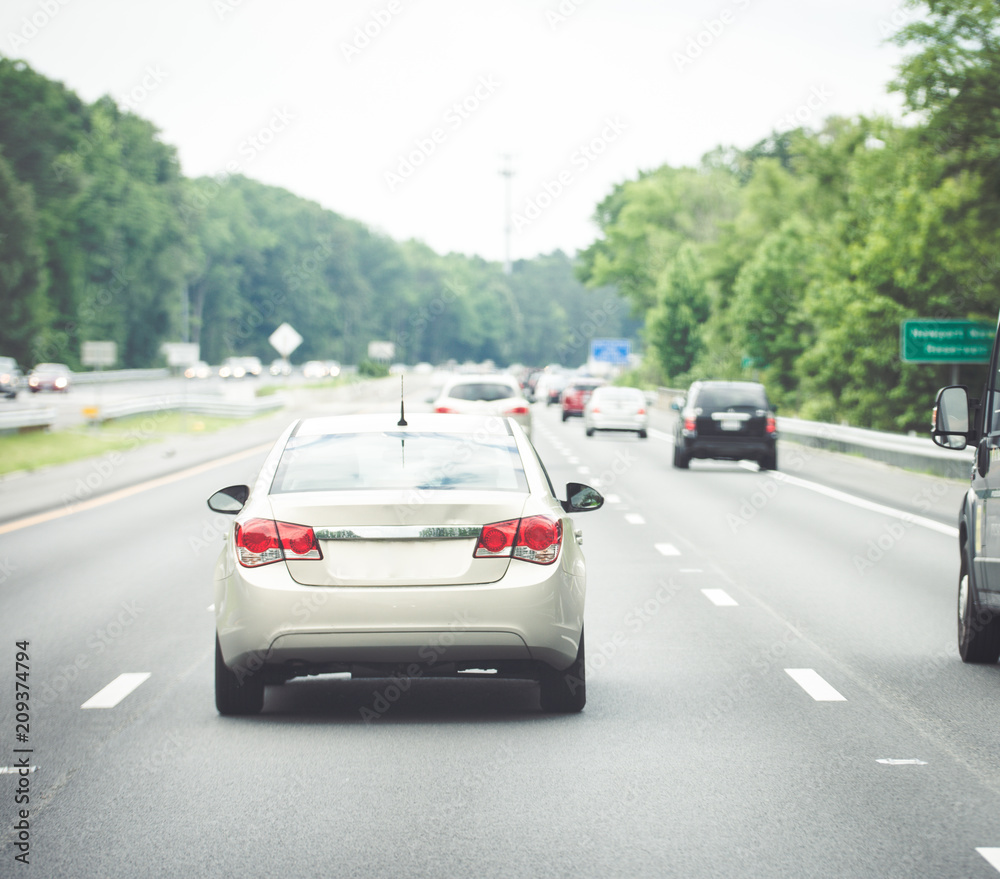Commuter economy car driving down road, rear view Stock Photo | Adobe Stock