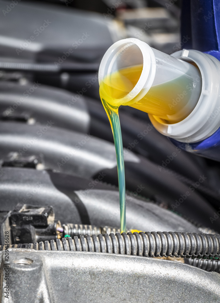 Filling the engine oil into the engine from the canister. Stock Photo ...