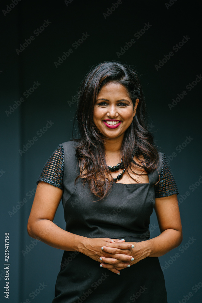 Portrait of a confident Indian woman in a studio. She is wearing an ...