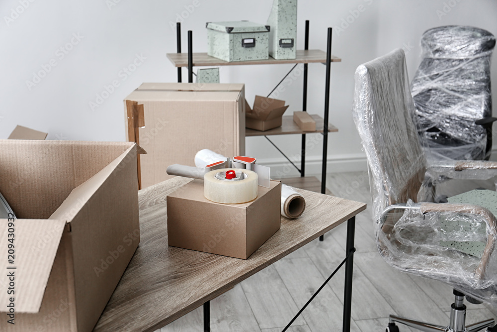 Carton boxes with stuff on table in room. Office move concept Stock ...