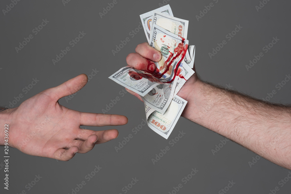 Hand injured bloody finger holds dollar banknote grey background. Dirty ...