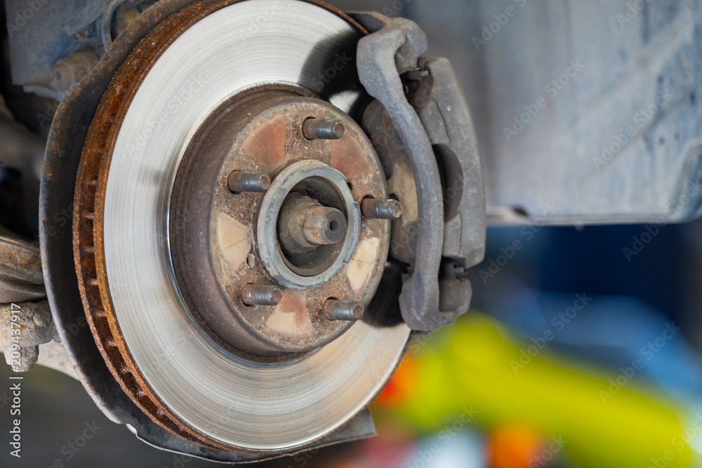 Front disc brake on car in process of service. The rim is removed ...