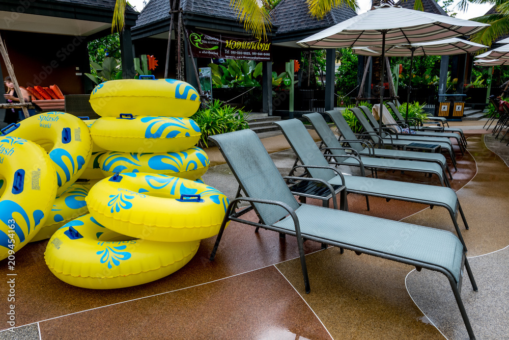 Yellow swim tubes with sunbeds in the water park. Stock Photo | Adobe Stock