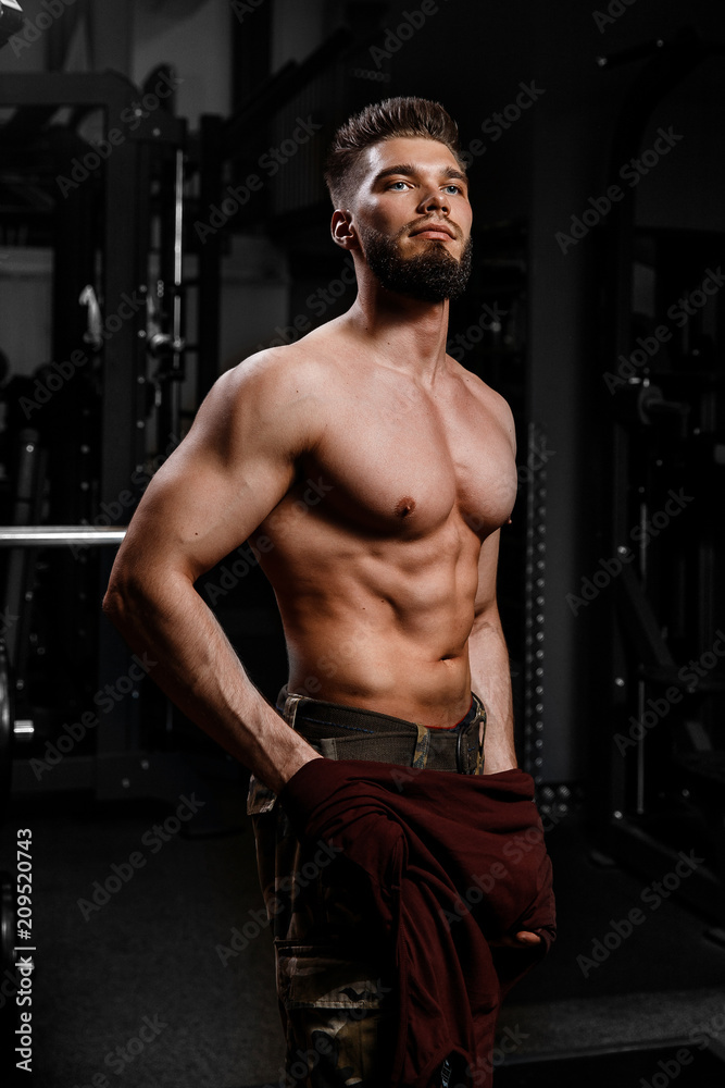 Man is standing in gym with inflated body, muscles of press are ...