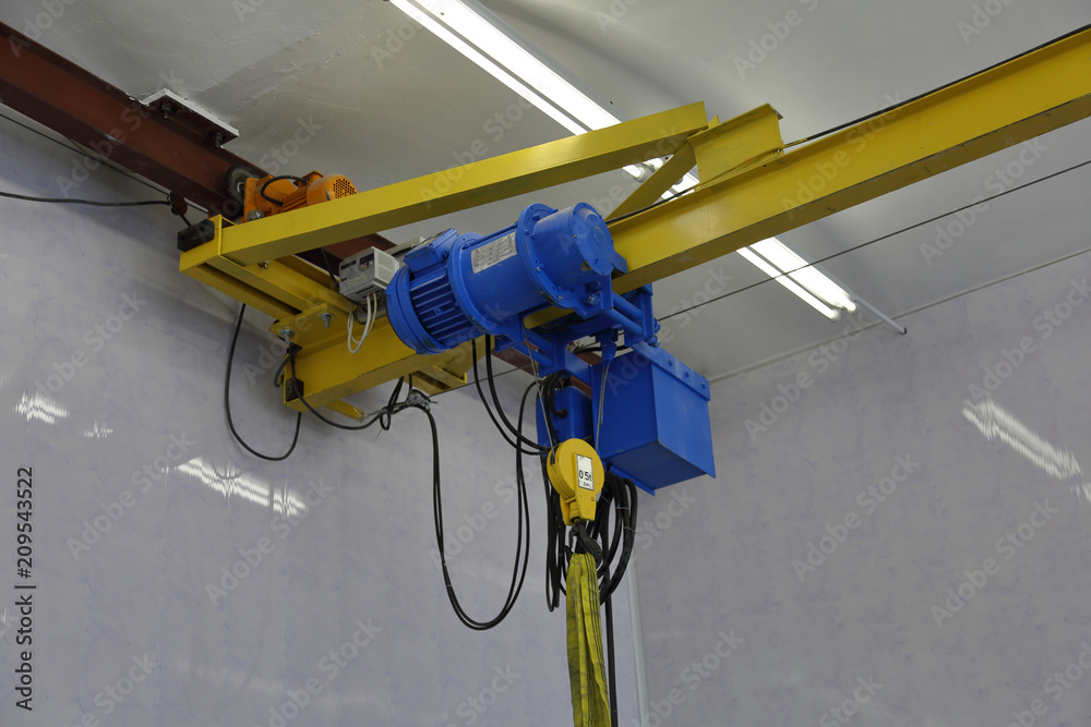 A horizontal crane beam with an electric motor is used to lift and ...
