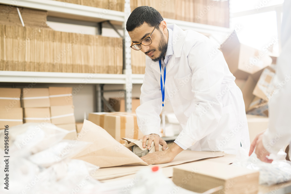 Measuring equipment factory worker wearing lab coat wrapping manometer ...
