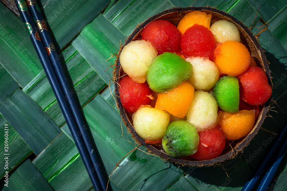 une coquille de noix de coco remplie d'une salade de fruit avec des ...